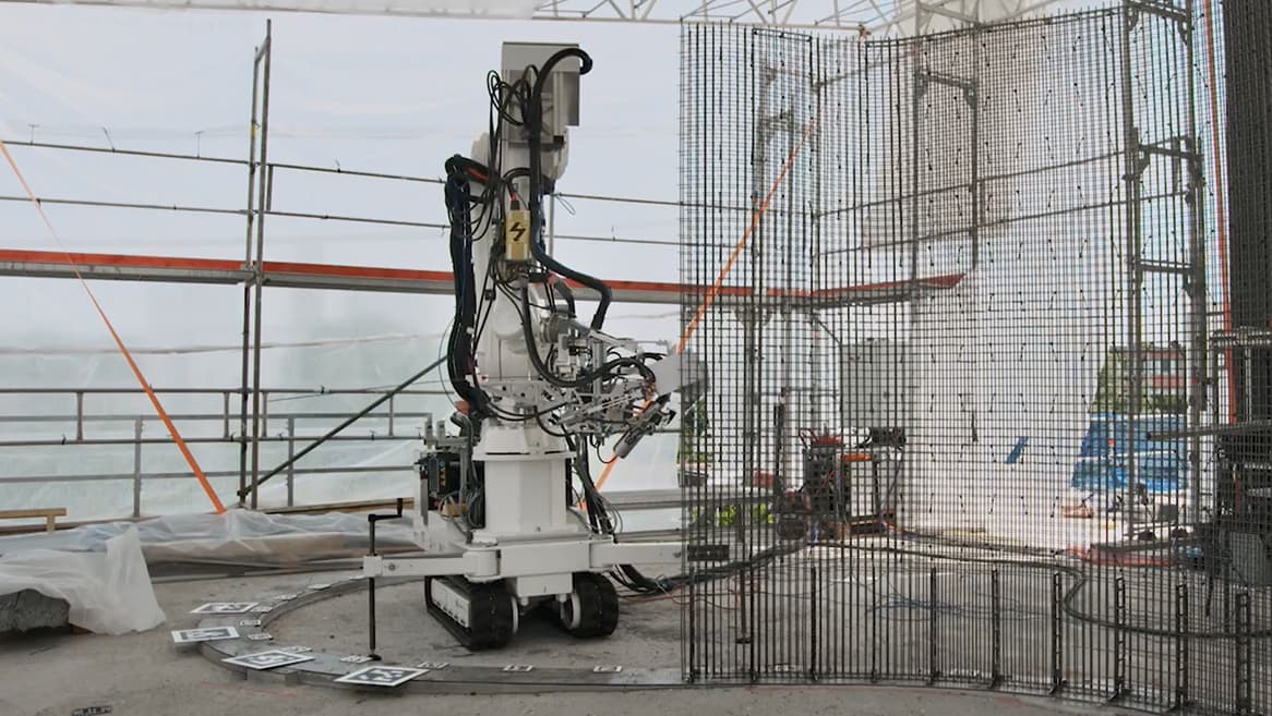 Pouring concrete onto rebar that robots tied
